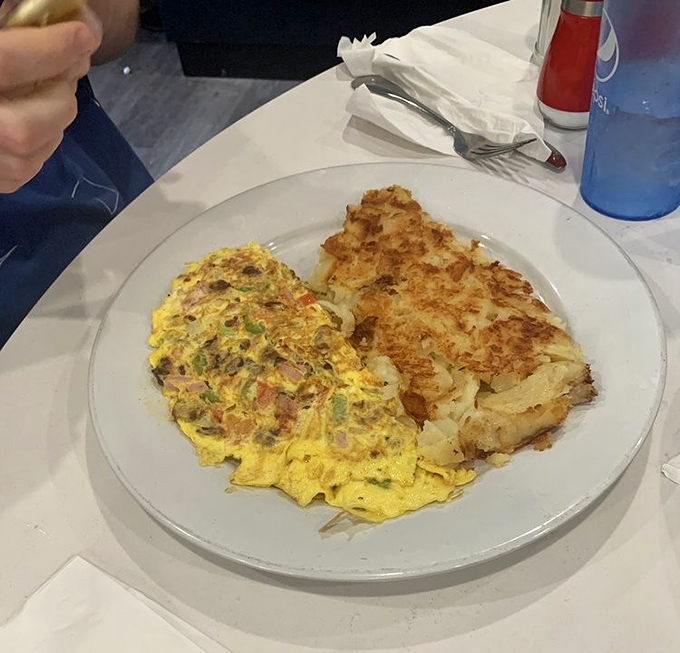 The country omelette and hash browns perform a perfect breakfast duet—one fluffy and filled with treasures, the other crispy and golden.