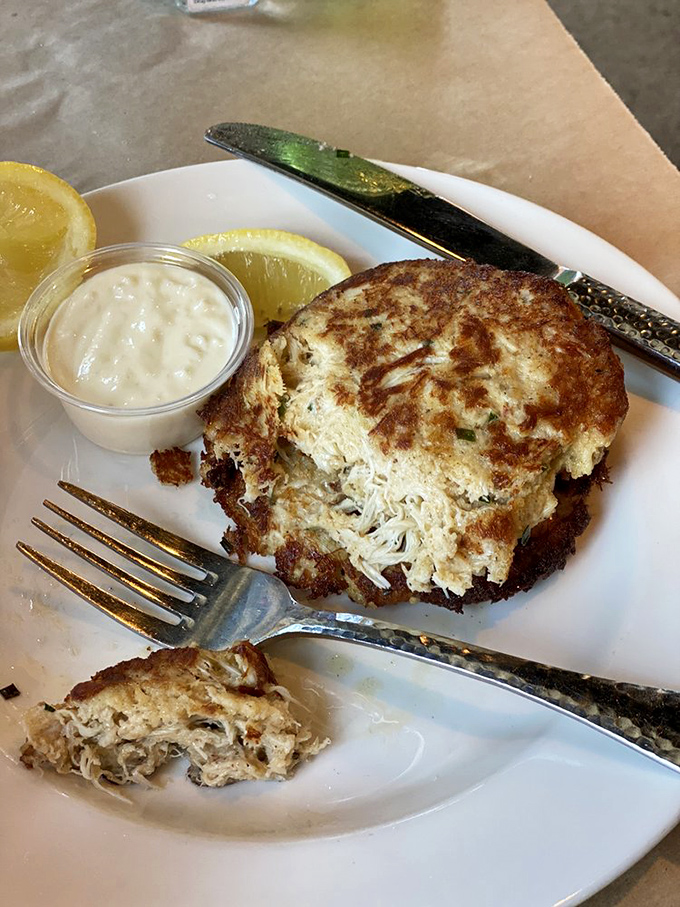 This golden-brown crab cake is what seafood dreams are made of&mdash;minimal filler, maximum crab, and a side of tangy sauce for dipping.