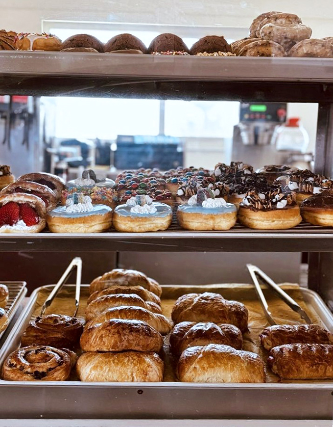 Heaven arranged on three tiers. From cream-filled wonders to chocolate-topped classics, this display case is where willpower comes to die a delicious death.