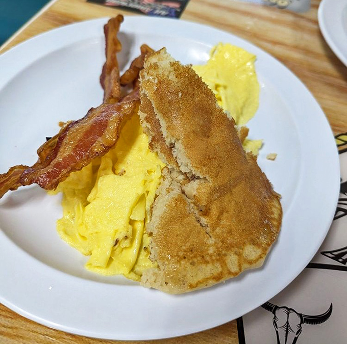 Breakfast perfection doesn't need to be complicated. Golden scrambled eggs, crispy bacon, and a pancake that would make your grandmother proud.