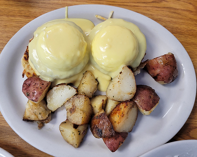 Eggs Benedict done right: perfectly poached eggs, silky hollandaise, and home fries that make you question every other potato you've ever eaten.
