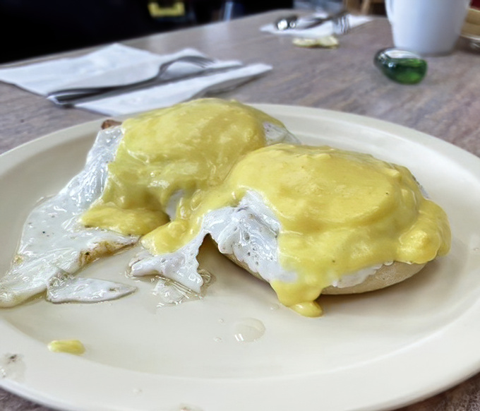 Eggs Benedict done right—golden hollandaise cascading over perfectly poached eggs. Breakfast architecture that would make Frank Lloyd Wright proud.