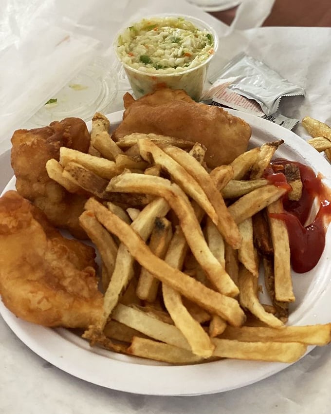 The holy trinity of comfort food—golden fish, hand-cut fries, and coleslaw that doesn't apologize for being exactly what it should be.