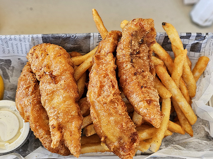 Golden-battered fish so crispy you can hear the crunch three tables away, paired with fries that deserve their own fan club.