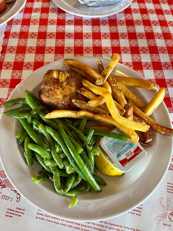A crab cake that doesn't hide behind fancy garnishes—just honest seafood with green beans that actually taste like vegetables should.