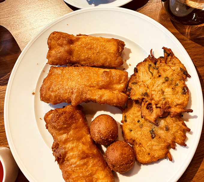 Wisconsin's fish fry tradition gets the royal treatment with golden-battered perfection, potato pancakes, and those adorable little spheres of deep-fried joy.