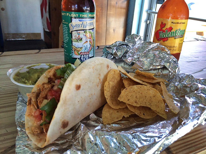 The holy trinity of taco enjoyment: a perfectly grilled fish taco, house-made chips that shatter with each bite, and guacamole that California would envy.