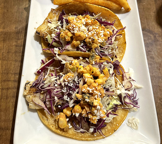 Fish tacos dressed to impress with enough colorful toppings to make a rainbow jealous of dinner.