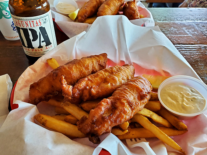 Fish and chips that achieve the impossible: golden-crisp exterior giving way to flaky perfection within. The cold beer is non-negotiable.