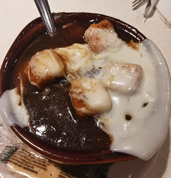 French onion soup that doesn't just warm your body but hugs your soul, with that perfect cheese pull that deserves its own slow-motion sequence.