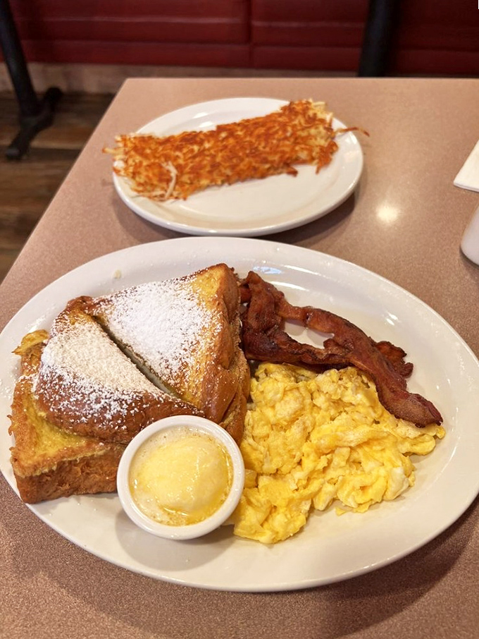 French toast dusted with powdered sugar, alongside eggs that would make any chicken proud. Breakfast harmony on a plate.