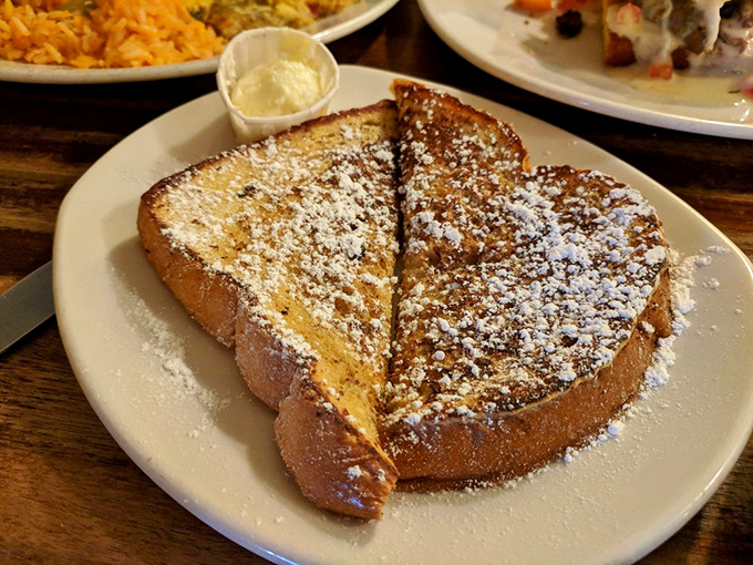 French toast that's been living its best life – dusted with powdered sugar like it just came in from a delicious snowstorm.