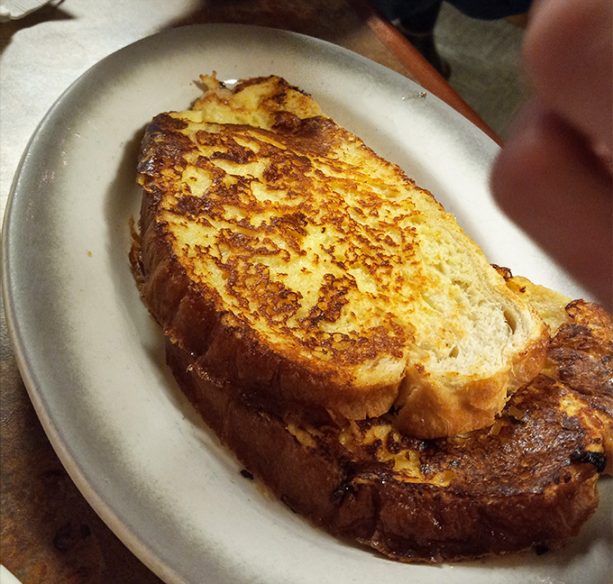 This French toast has clearly been to finishing school—golden-brown, perfectly crisp edges with a custardy center that would make Julia Child slow clap.