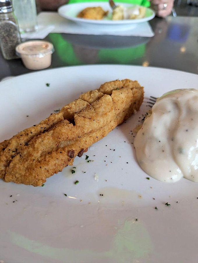 This golden-fried catfish isn't just dinner, it's Southern poetry with a crispy crust and a side of creamy sauce for dipping.