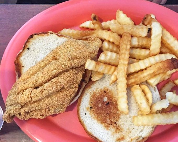 Crispy catfish sandwich with perfectly golden fries. The cornmeal coating delivers that satisfying crunch that makes you wonder why anyone would bread fish any other way.