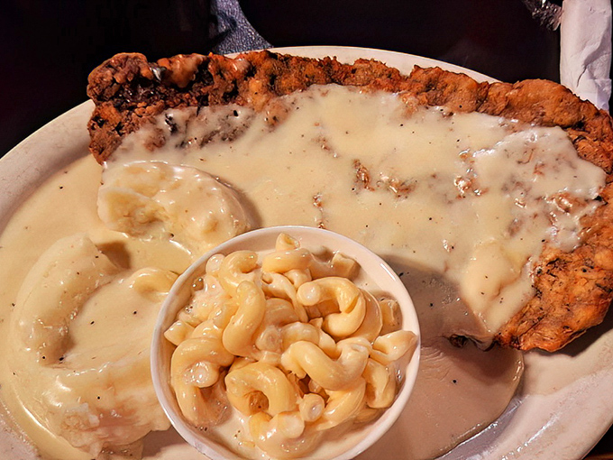 Country-fried steak swimming in creamy gravy with mac and cheese&mdash;comfort food that doesn't just hug you, it bear-hugs your soul.