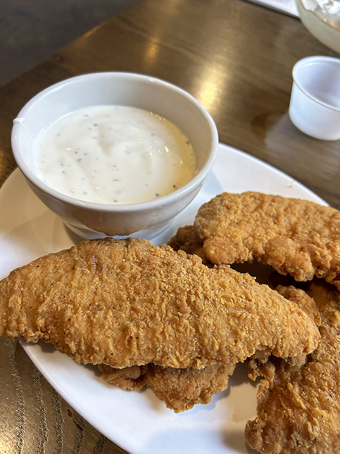 Golden-brown chicken strips that crunch louder than your dad's favorite recliner, paired with gravy that could make cardboard taste gourmet.