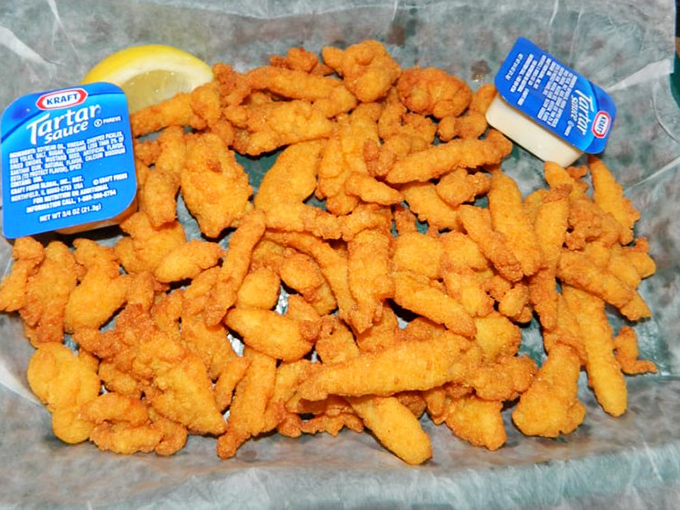 Golden fried clam strips pile high like edible sunshine, promising that perfect crunch with every bite.