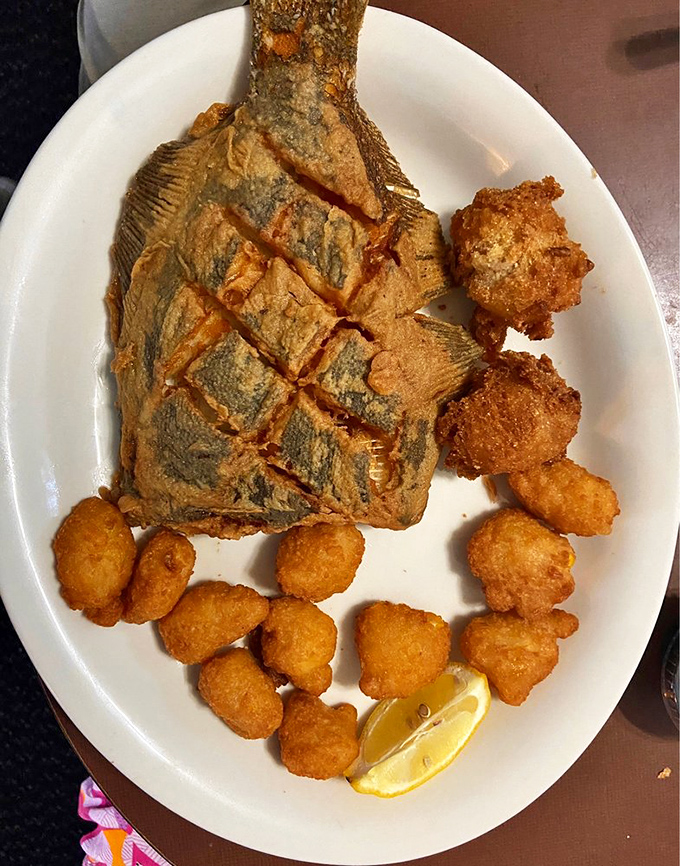 The flounder's scored pattern isn't just for show—it ensures perfect cooking and maximum flavor absorption. Those hushpuppies are no silent witnesses.