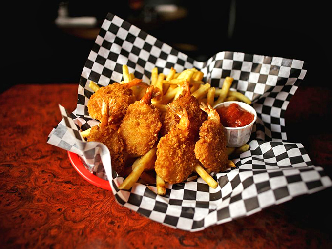 Golden-crisp butterfly shrimp that snap when you bite them, served unpretentiously in a checkered basket – comfort food perfection.