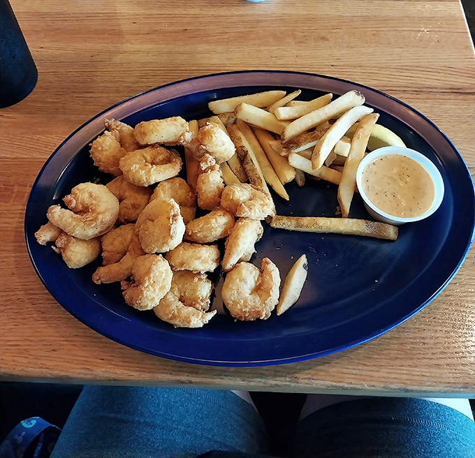 Golden-fried shrimp that snap with each bite, paired with crispy fries and a dipping sauce that makes you wonder why you'd eat seafood anywhere else.