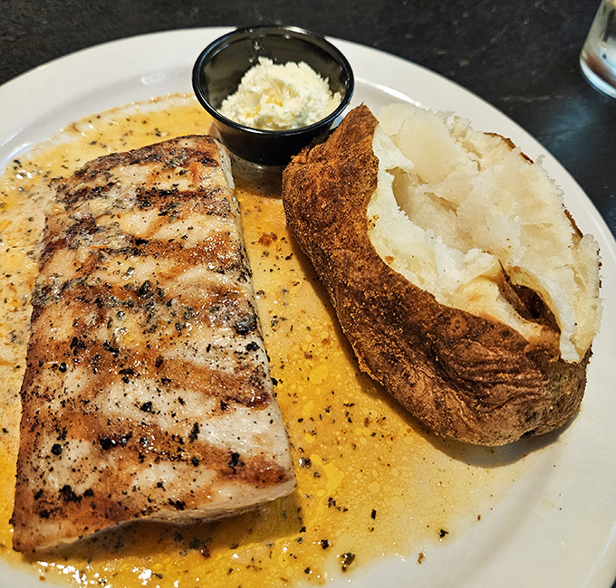 This grilled fish looks like it's floating on a sea of buttery goodness, with a baked potato standing by like a starchy lifeboat of deliciousness.