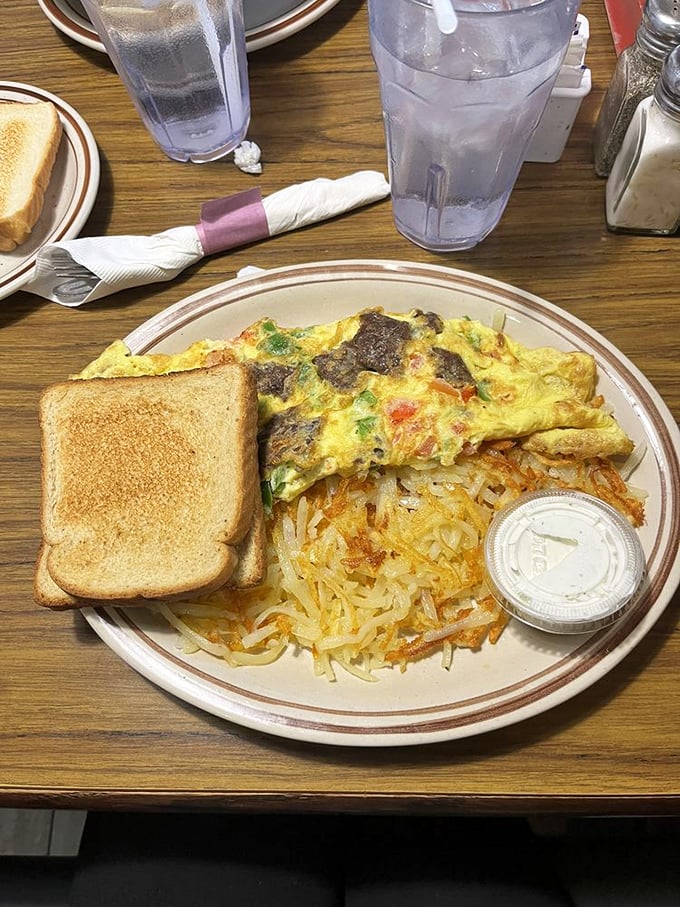 Breakfast architecture at its finest &ndash; a colorful omelet alongside hash browns with that perfect crisp-to-tender ratio that haunts your breakfast dreams.