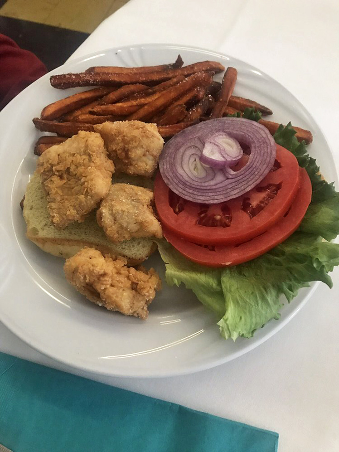 The fried grouper sandwich&mdash;where Gulf-fresh fish meets crispy perfection. Those sweet potato fries aren't just sidekicks; they're co-stars.
