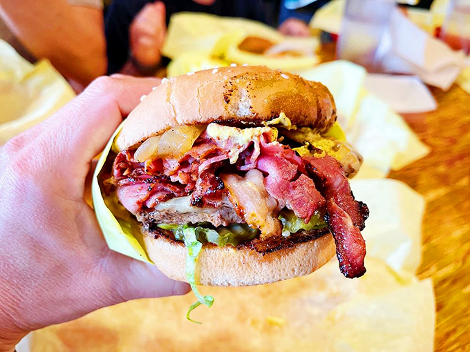 The bacon doesn't just sit on this burger—it commands attention, draping over the edges like it's making itself comfortable for the long haul.