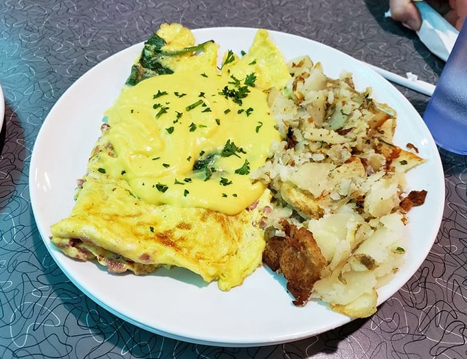 This isn't just an omelet&mdash;it's architecture. Layers of ham, cheese, and spinach create the foundation, while hollandaise adds the golden roof.