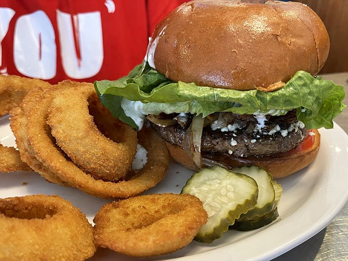 This isn't just a burger&mdash;it's architectural perfection. Golden onion rings stand at attention alongside a masterpiece that makes fast food chains weep with inadequacy.