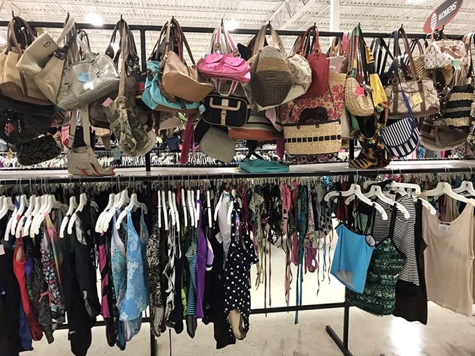 The handbag heaven hovers above clothing racks like fashion clouds, each purse with its own history and ready for a second act.