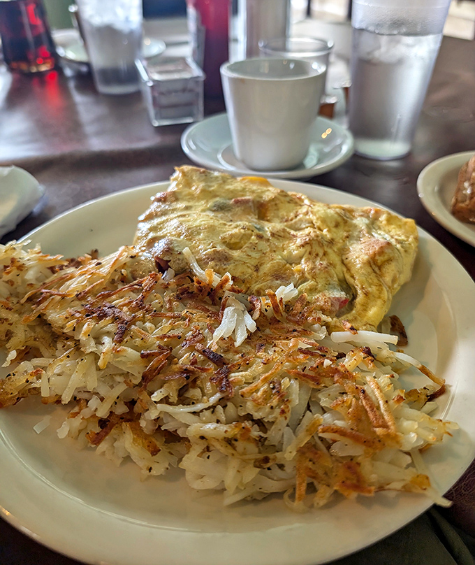 This omelet doesn't just sit on the plate &ndash; it lounges confidently beside a crown of crispy hash browns like it owns the place.