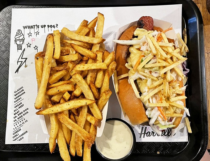A Carolina Dog with slaw alongside golden fries and house sauce &ndash; proof that sometimes the best things in life come in paper boats.