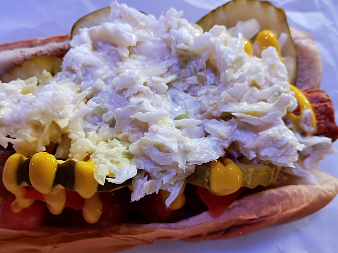 The coleslaw-topped hot dog doesn't care about your Instagram feed—it's too busy preparing to deliver a symphony of textures and flavors.