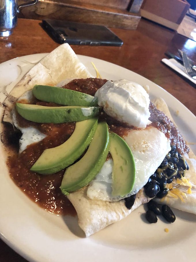Huevos rancheros with avocado slices fanned out like a green peacock. Breakfast that doubles as edible art and hangover cure.