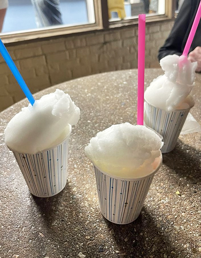 Three cups of Italian ice standing at attention like frozen sentinels, their colorful straws promising the perfect palate-cleansing finale to your beef odyssey.