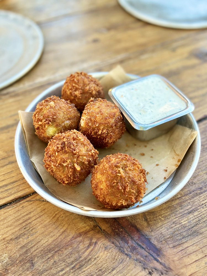 Golden-fried arancini balls: crunchy on the outside, molten magic on the inside. The dipping sauce is just showing off.