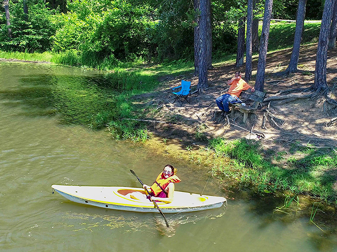Childhood summers distilled into one perfect scene: a young kayaker explores the shoreline while adults keep watch&mdash;the original family entertainment system.