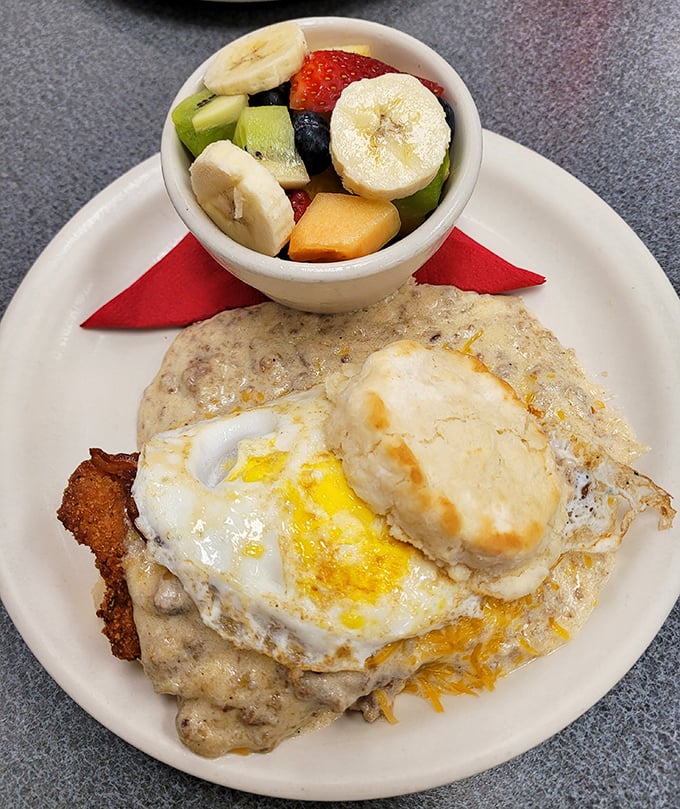 Biscuits and gravy with a sunny-side up egg on top? This plate isn't just breakfast; it's Southern poetry on porcelain.