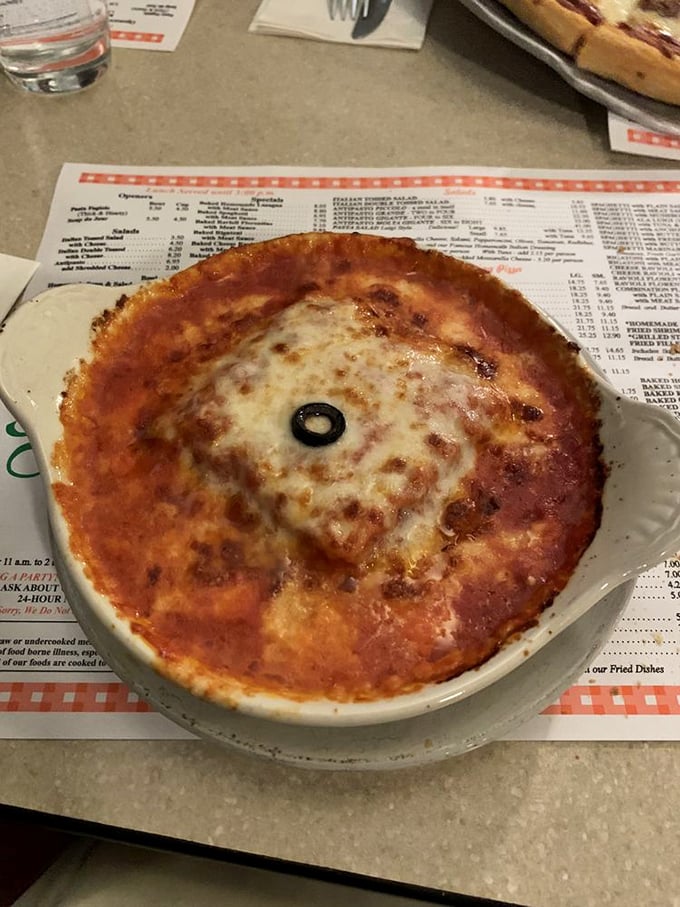 A personal-sized lasagna with a single olive sentinel standing guard. This isn't just comfort food&mdash;it's therapy without the hourly rate.