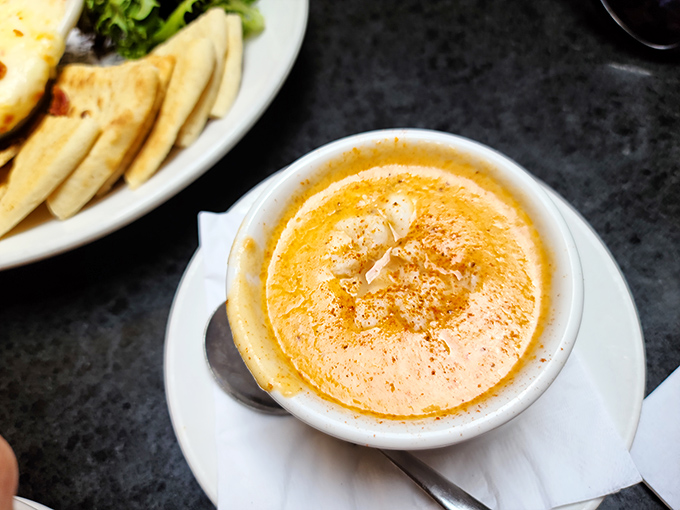 This lobster bisque isn't just soup – it's a velvety orange pool of happiness that makes spoons feel like they've won the lottery.