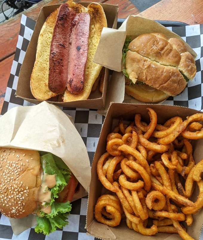 The holy trinity of American road food: a perfectly grilled hot dog, a classic burger, and curly fries that could make a food critic weep with joy.