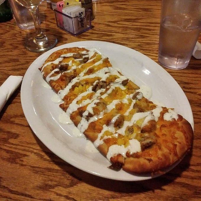 Flatbread that defies categorization &ndash; crispy, cheesy, and drizzled with creamy sauce. The kind of appetizer that ruins your appetite because you can't stop eating it.