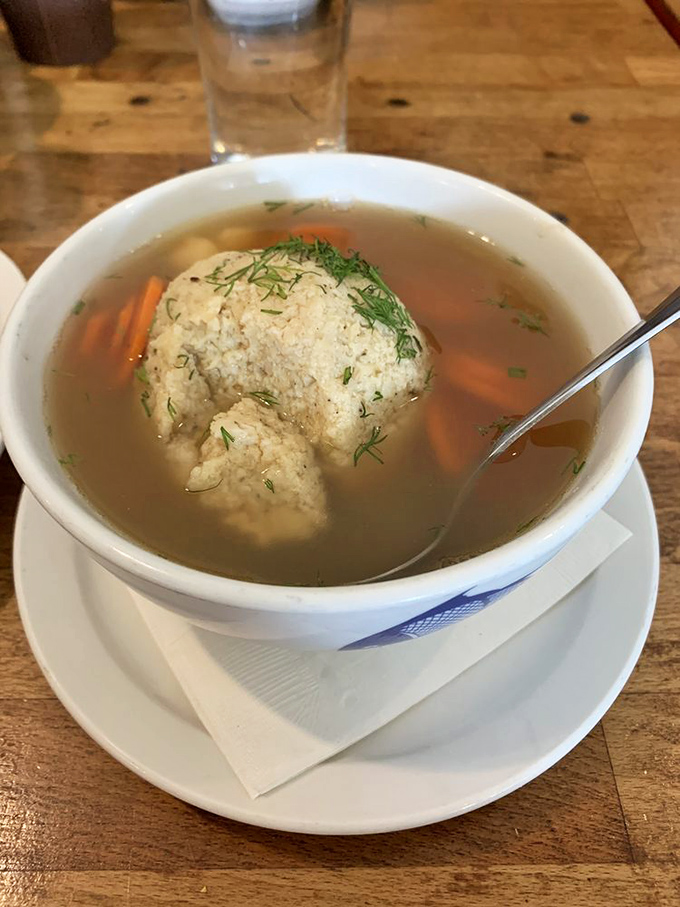 The matzo ball soup &ndash; where a fluffy dumpling island floats in a sea of golden broth that could cure anything from colds to existential crises.