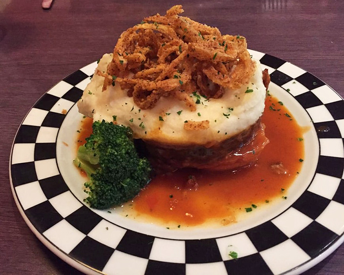 Meatloaf reimagined: topped with crispy onion straws and sitting on a throne of mashed potatoes. Grandma would be jealous&mdash;and impressed.