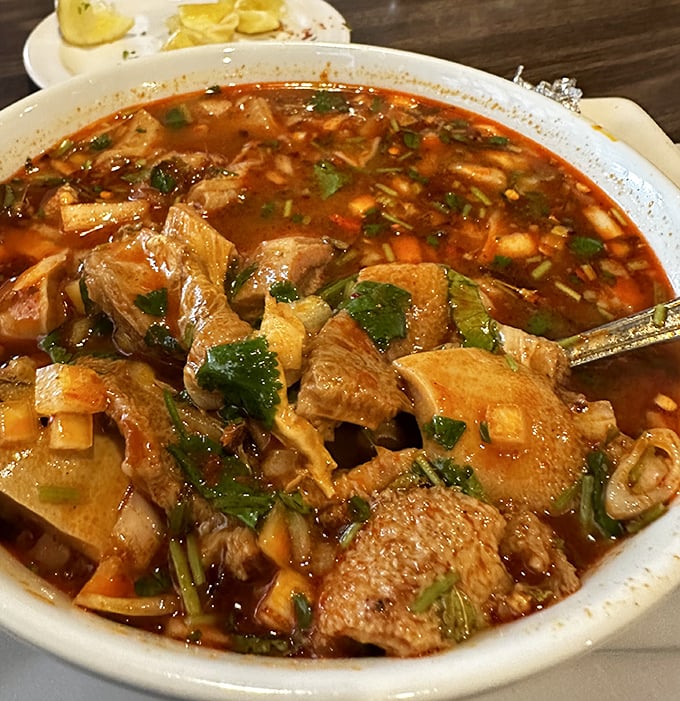 This menudo isn't just soup; it's a spicy, soul-warming ritual in a bowl, with tender tripe and vegetables swimming in rich, red broth.