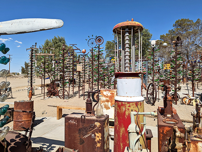 Rusty gold meets gleaming glass. This vintage gas pump has found retirement among colorful companions, like a dignified elder at a carnival.