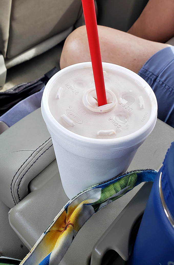 Road trip essential: a thick, creamy milkshake in a styrofoam cup with that signature red straw. The perfect companion for one-handed driving.