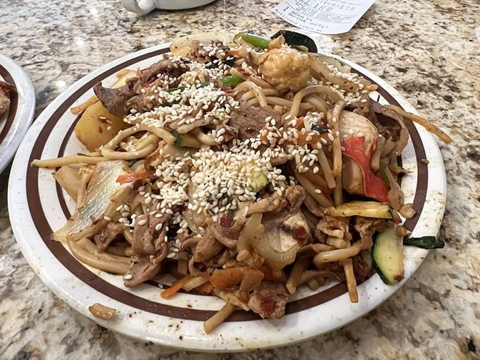 This isn't just noodles&mdash;it's a canvas of flavors where sesame seeds rain down like delicious confetti on a celebration of textures and tastes.